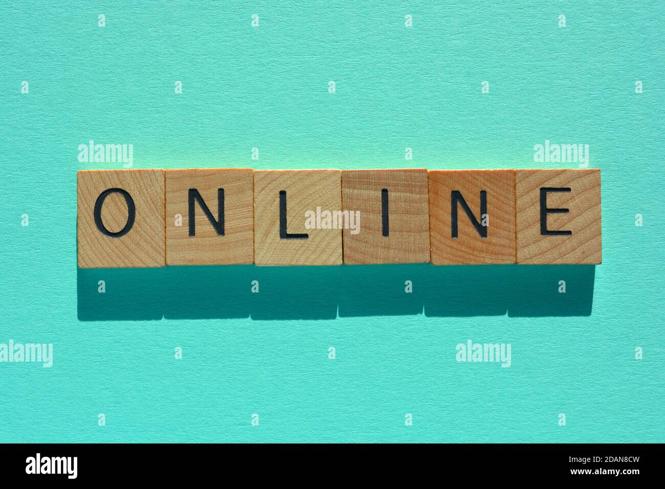 Online, word in wooden alphabet letters isolated on turquoise ...