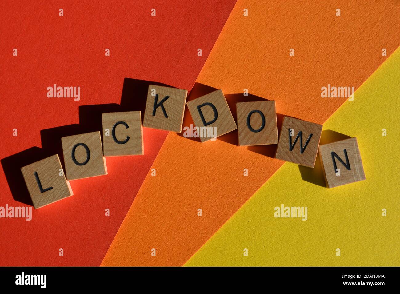 Lockdown, word in wooden alphabet letters isolated onn red, orange and ...