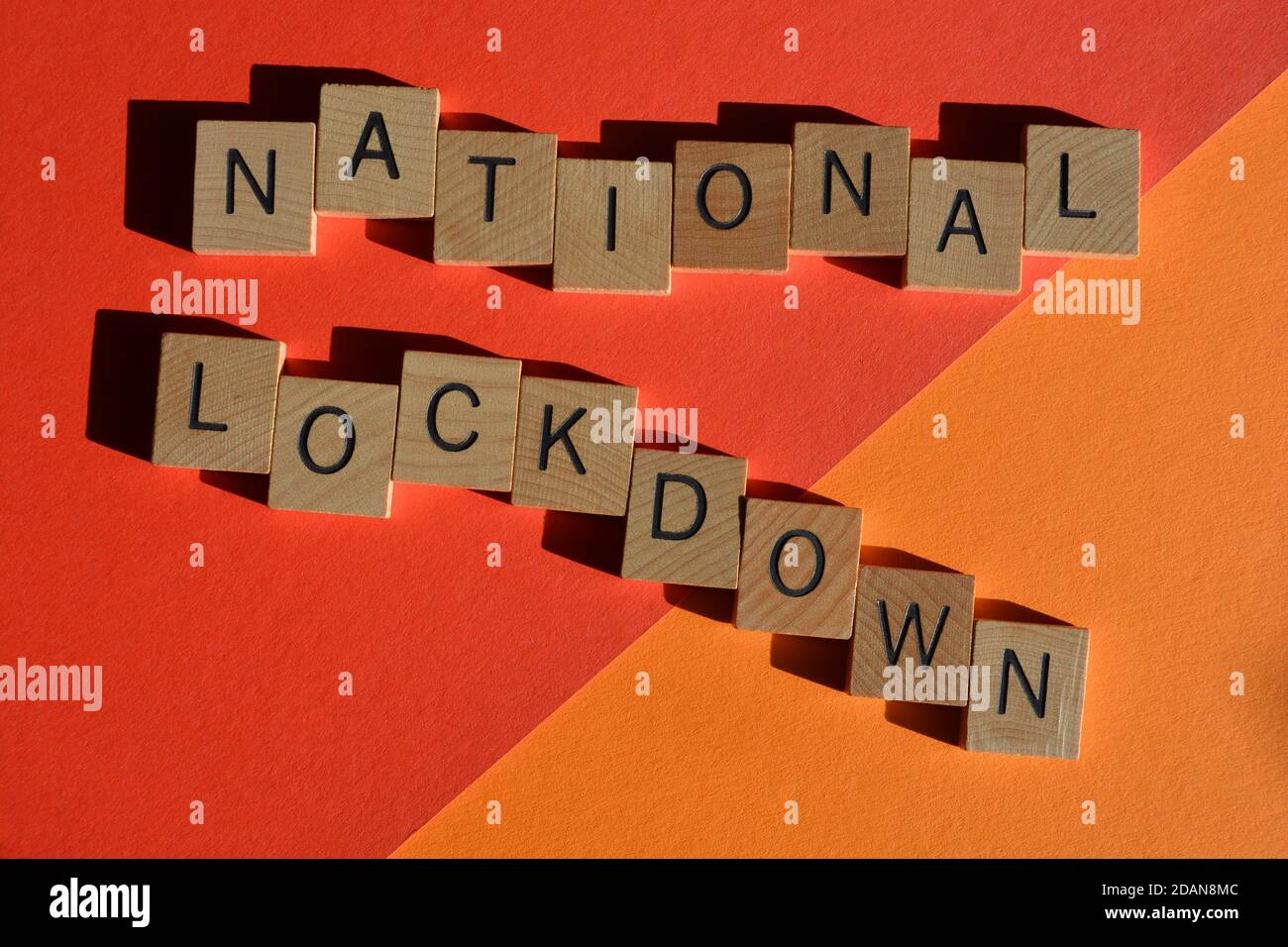 National lockdown, words in wooden alphabet letters on red and orange ...