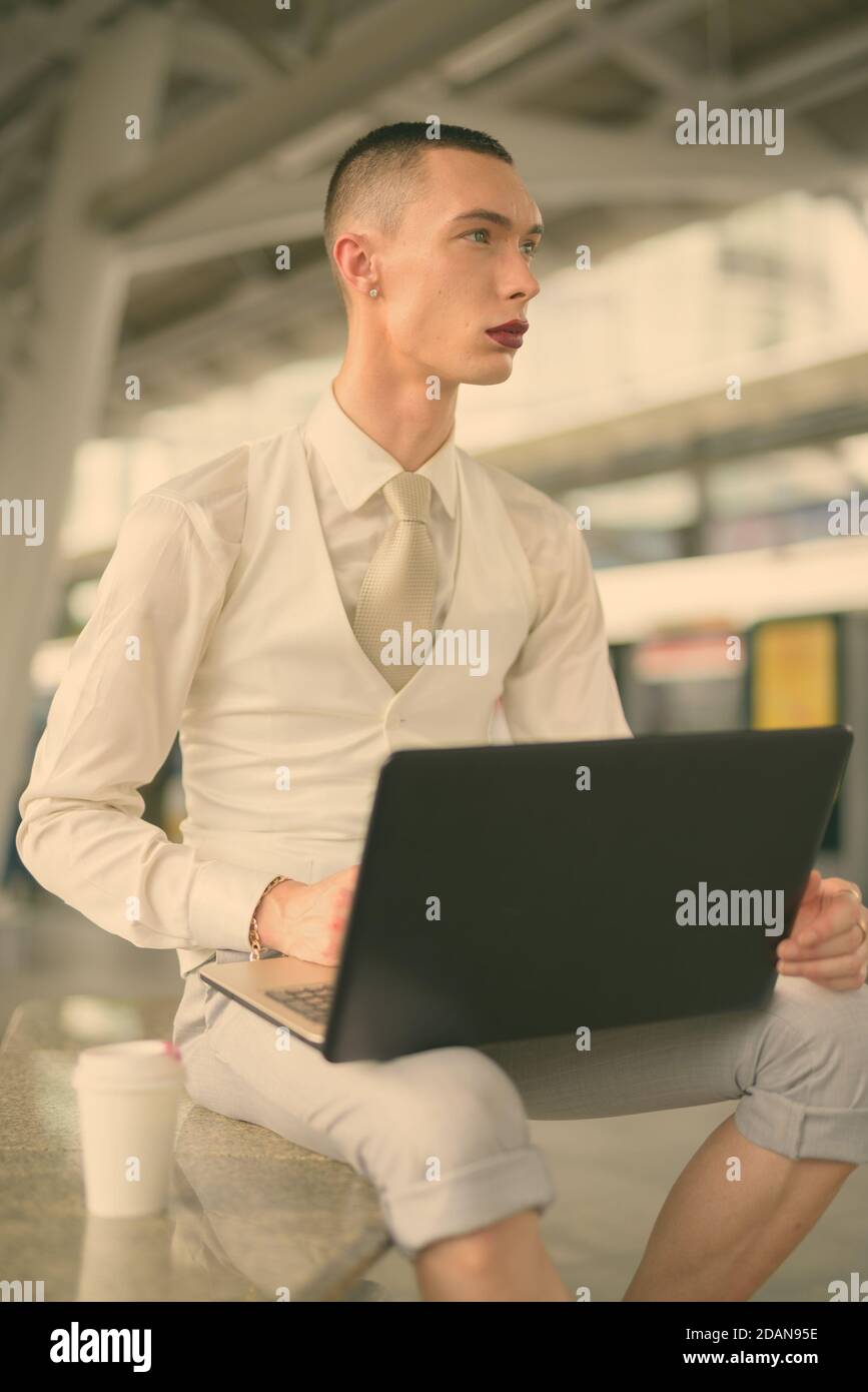 Young handsome androgynous businessman exploring the city of Bangkok ...