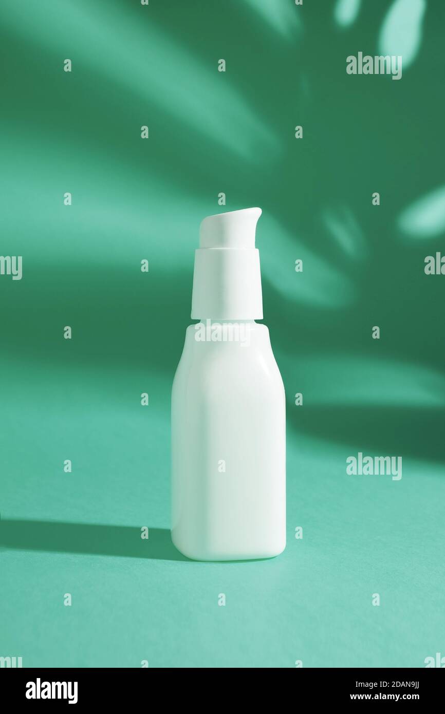 White ceramic opaque bottle on a bright green background without labels ...