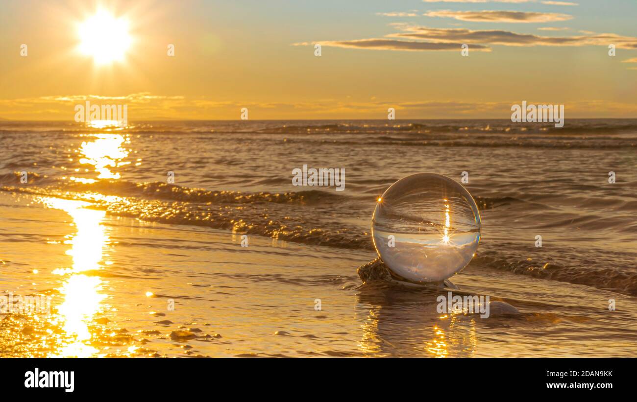 Reflection in a glass at sunset on a beach Stock Photo - Alamy