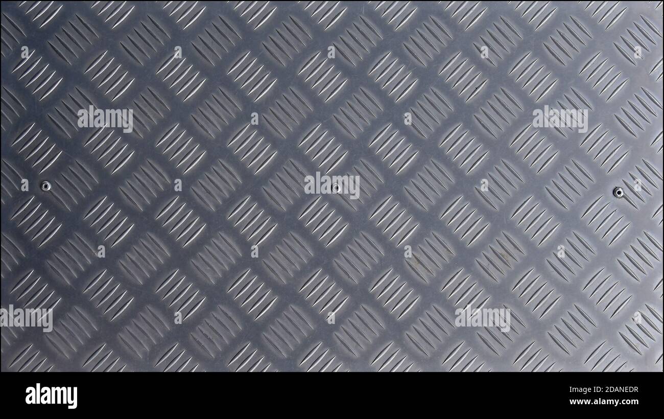 A stainless steel textured footplate with a regular pattern of ridges ...