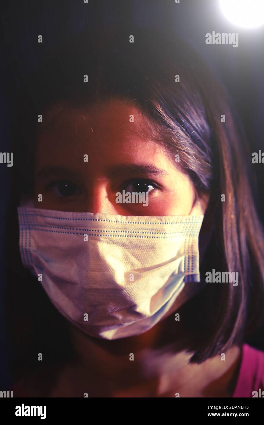 young girl with surgical mask and light behind creating a very dramatic ...