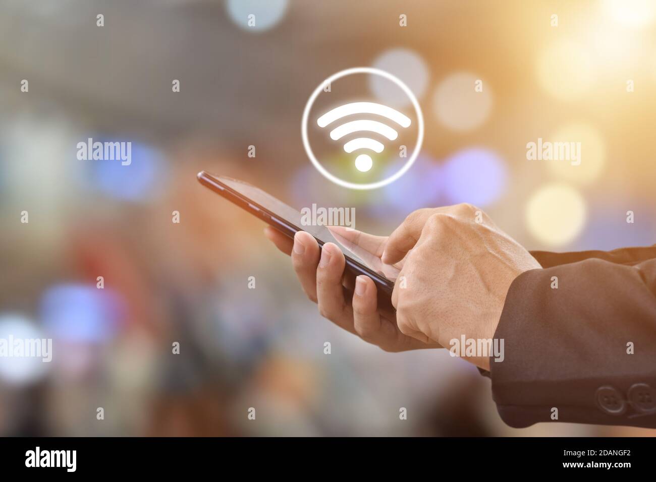 Close-up image of male hands using mobile smartphone with Wifi icon ...