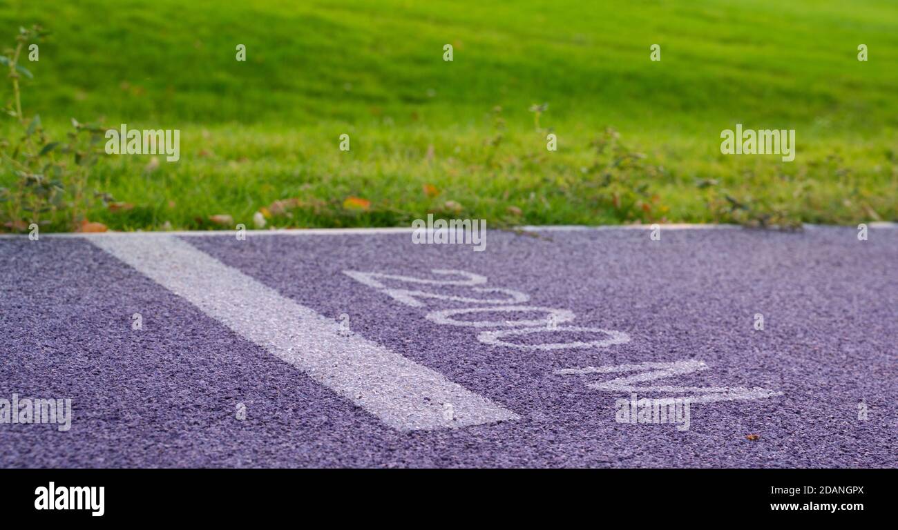 Jogging track in the park at summer day. 2000 meters distance sign ...