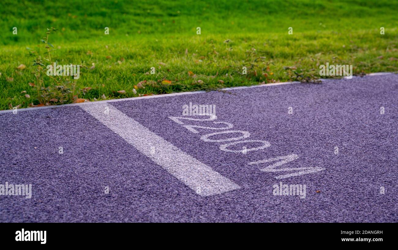 Jogging track in the park at summer day. 2000 meters distance sign ...