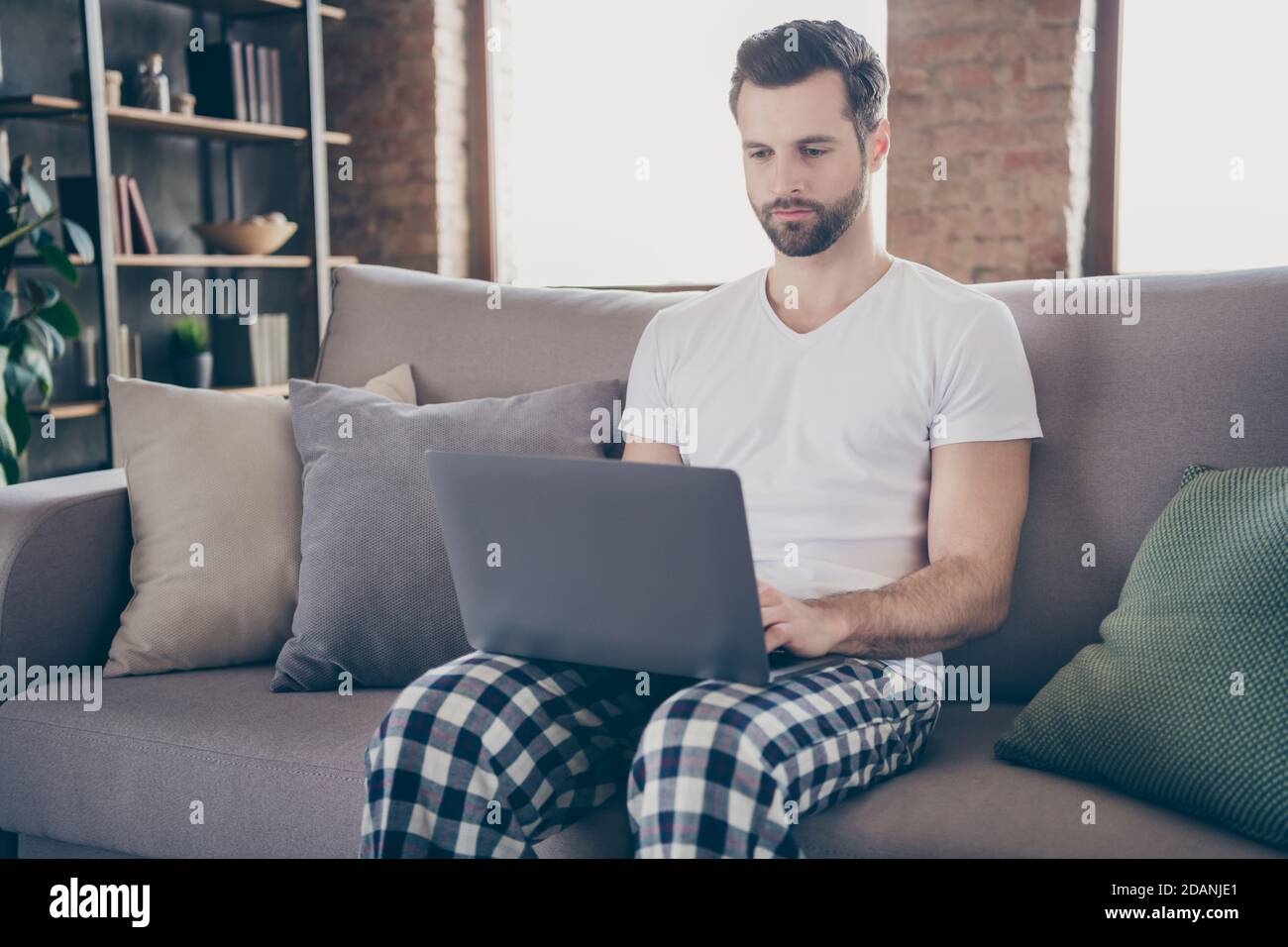 Portrait of his he nice attractive focused serious guy sitting on divan ... Portrait of his he nice attractive focused serious guy sitting on divan ...