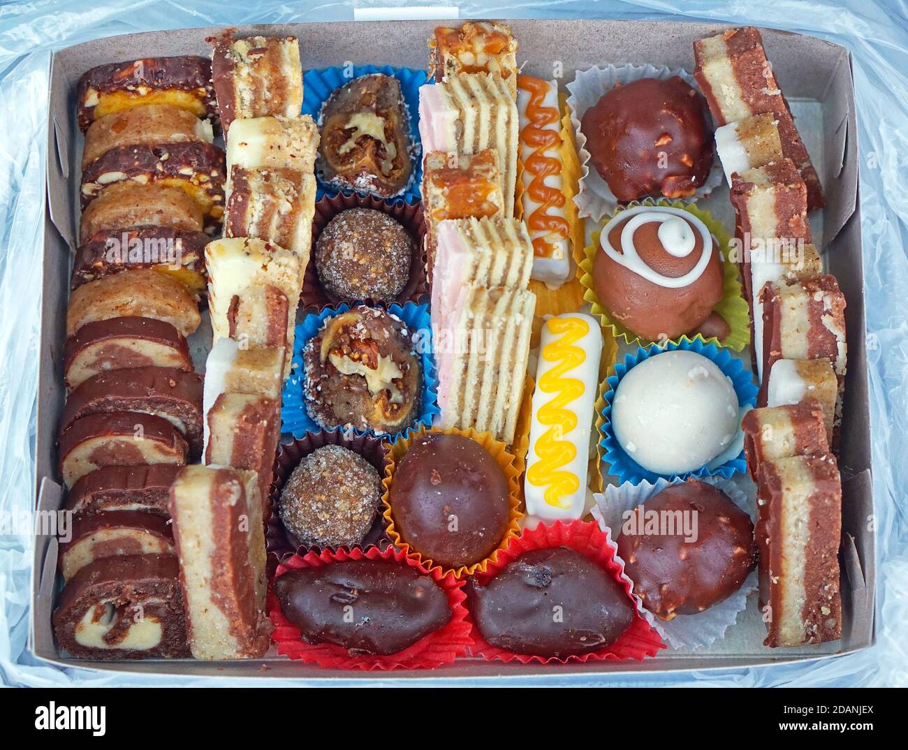 Many tiny cakes dessert selection in party box Stock Photo - Alamy