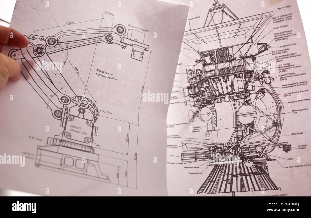 View of a person holding two technical engineering diagrams one ...