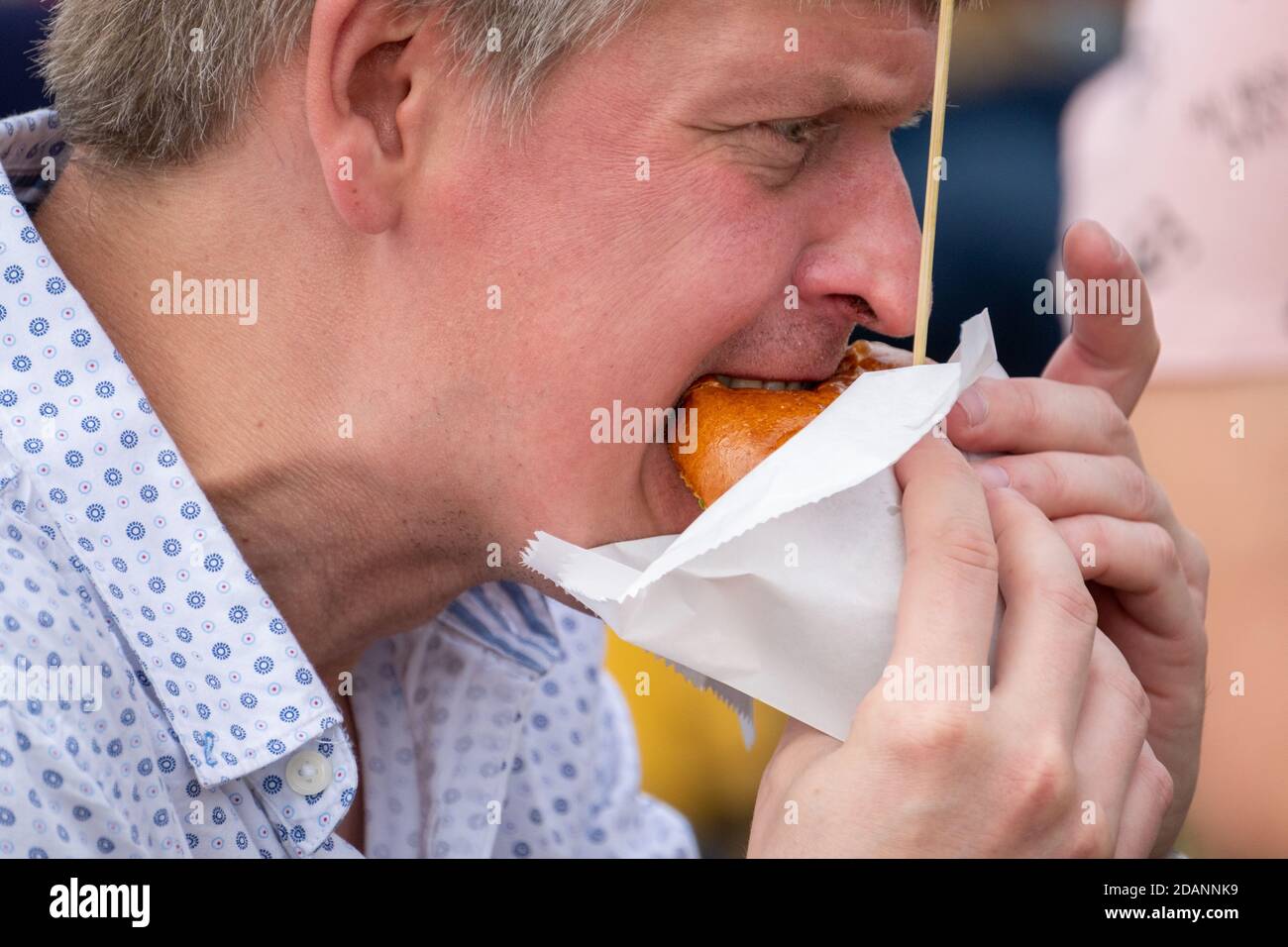 Hungry man eating yummy burger Stock Photo - Alamy