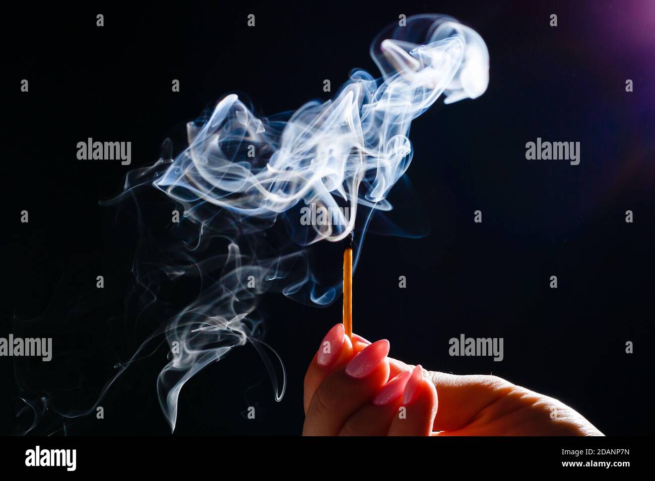 Hand holding match stick on black background Stock Photo - Alamy