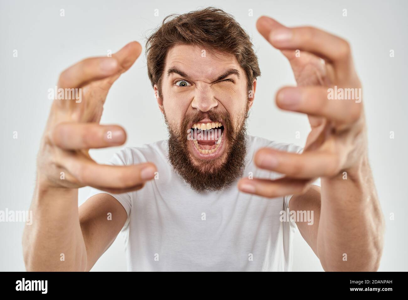 emotional man with a beard gesturing with his hands close-up studio ...