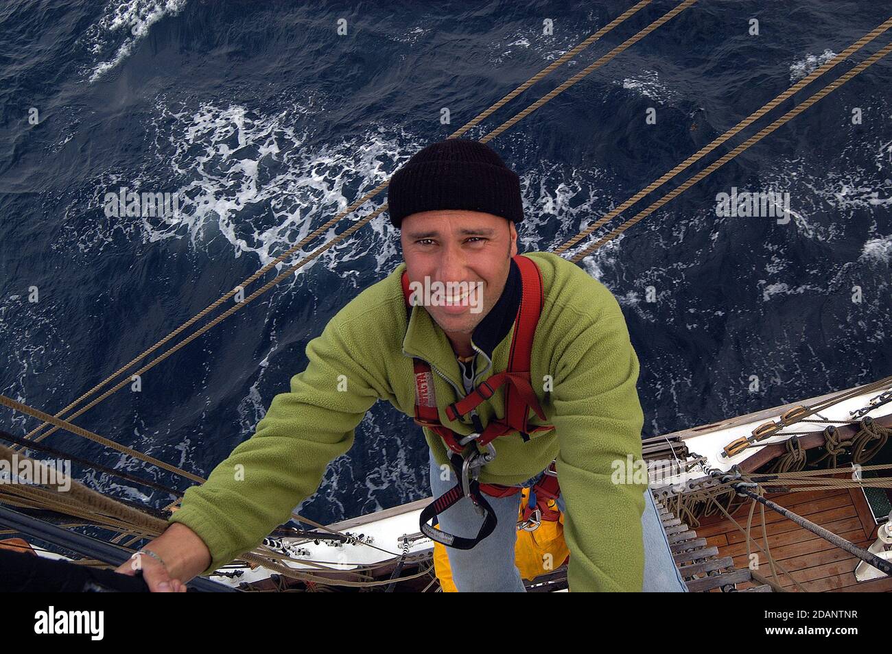 Seaman climbing up the ratins on a tall ship-that form a ladder for ...