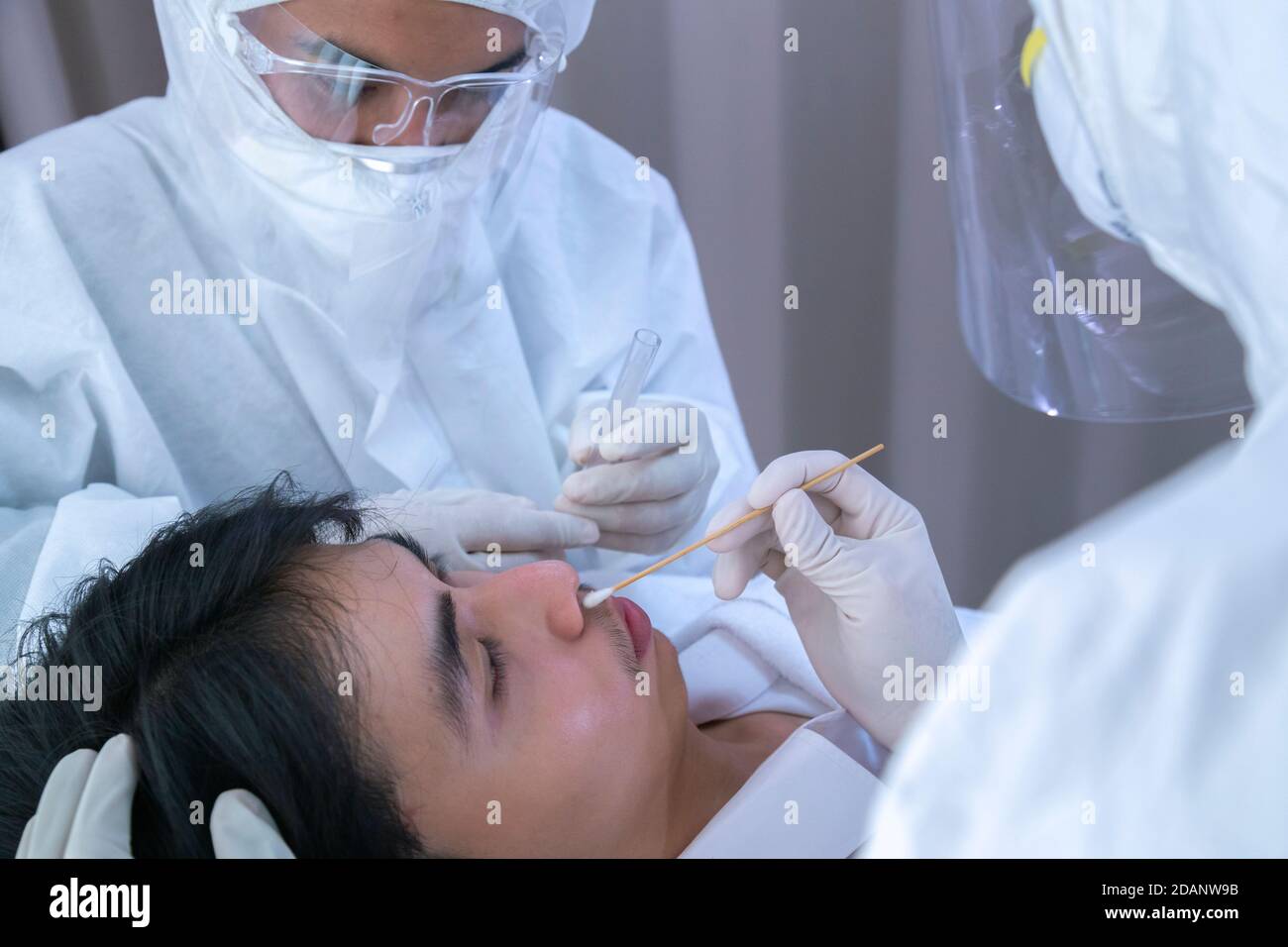 male nurse and doctor wearing ppe suit and facemask perform Coronavirus ...