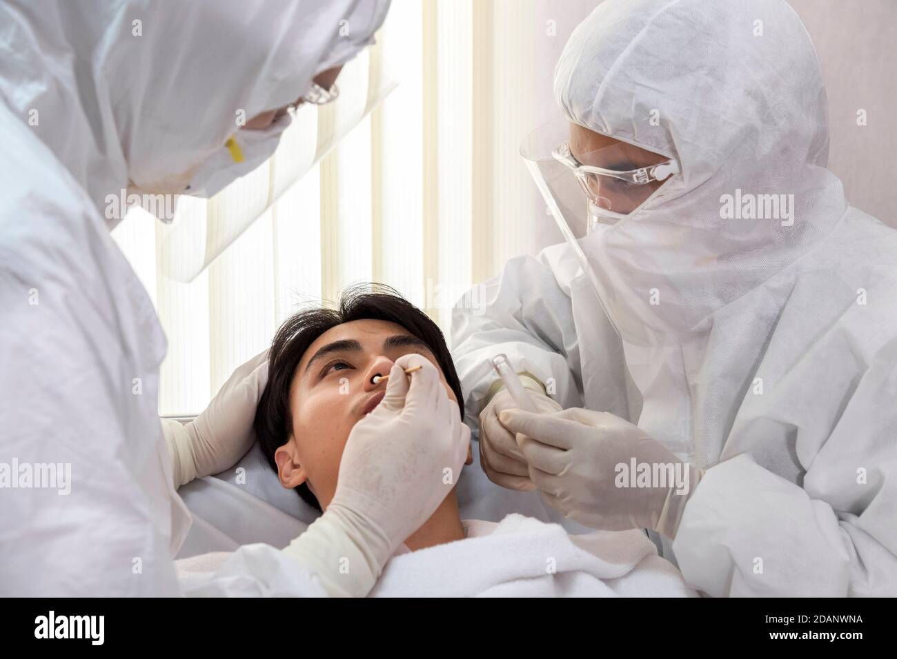 male nurse and doctor wearing ppe suit and facemask perform Coronavirus ...
