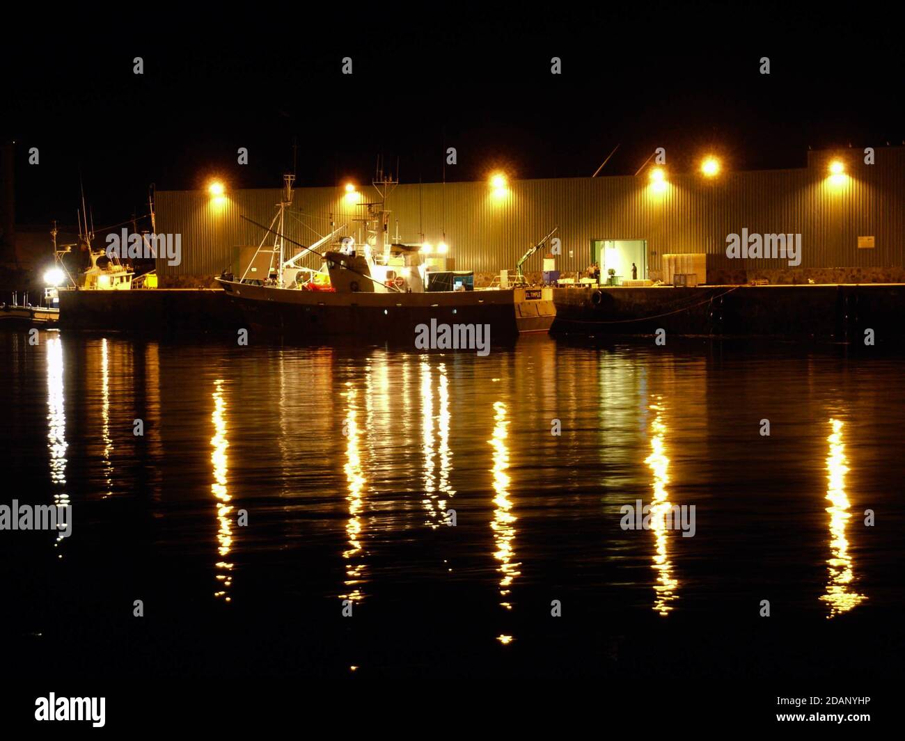 Illuminated dock with yellow lights reflection on the water Stock Photo ...