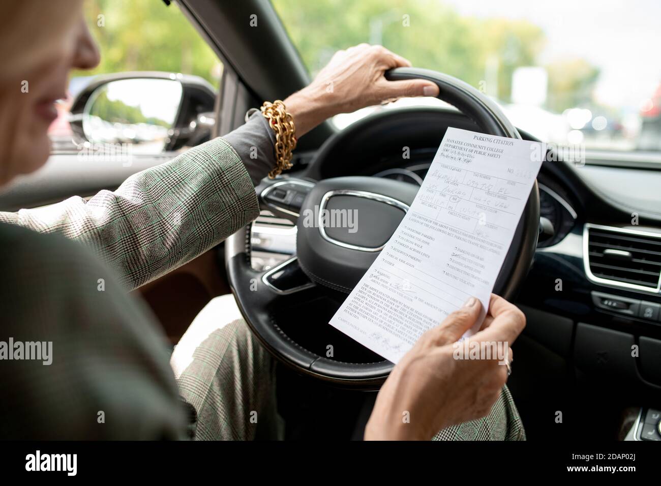 Hands of contemporary mature businesswoman looking through paper while ...