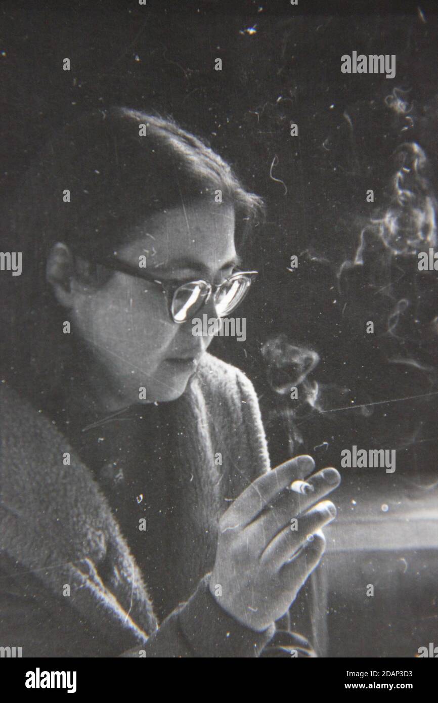Fine 1970s vintage black and white photography of a young woman smoking ...