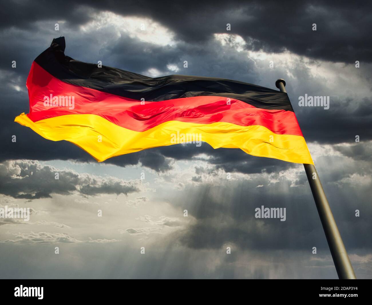 Flag of the Federal Republic of Germany on the flagpole in gray weather ...