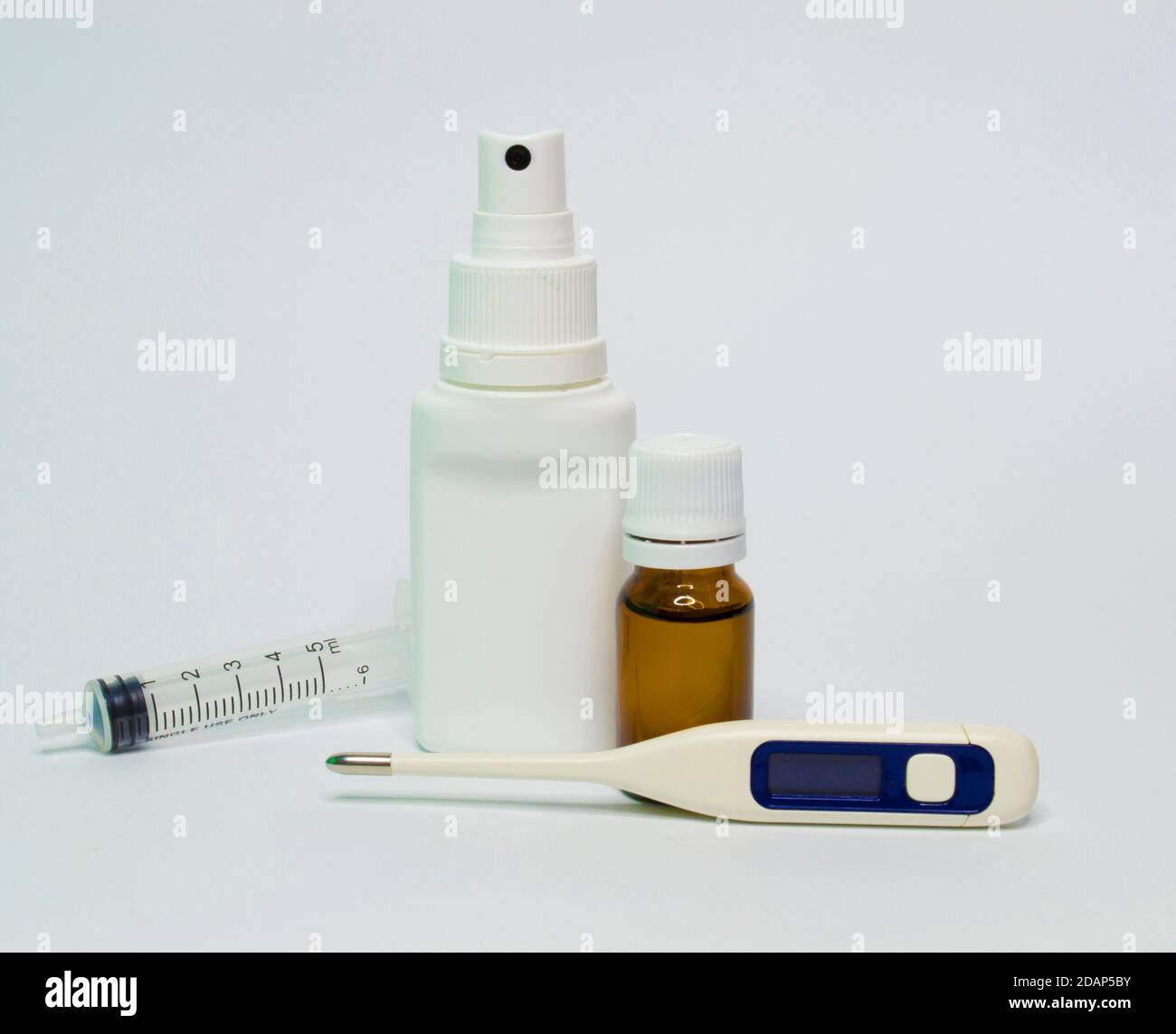 Syrup, spray, thermometer, face mask and syringe on gray background ...
