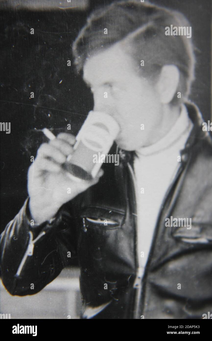 Fine 1970s vintage black and white photography of a young man smoking a ...