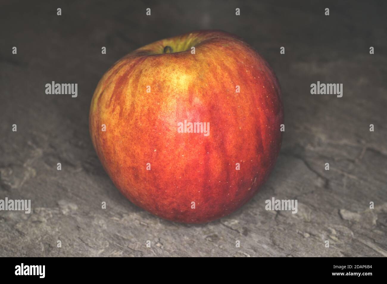 Closeup shot of a red apple on the ground surface Stock Photo - Alamy