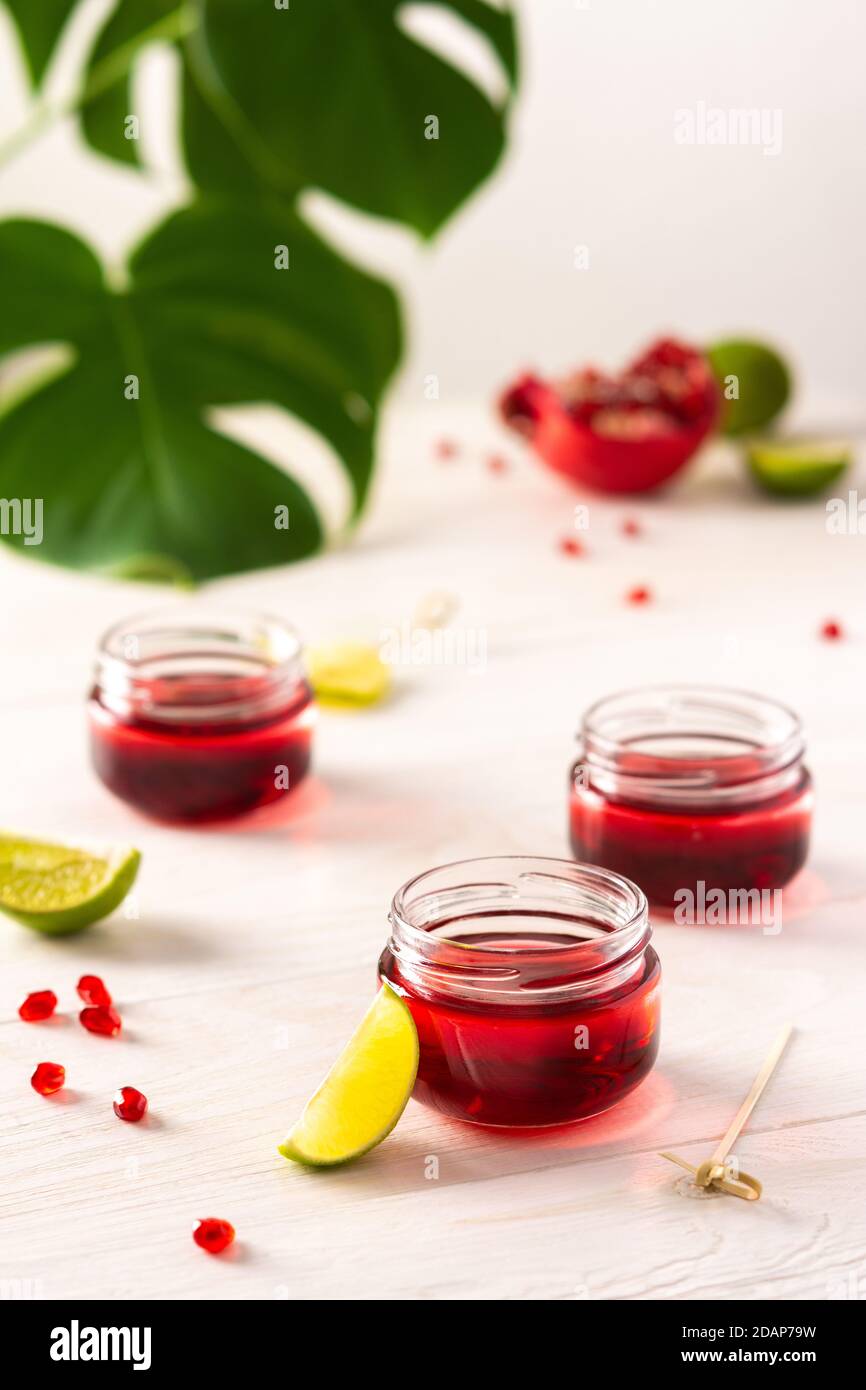 Red alcoholic shots on white background , small jars with liquor and ...
