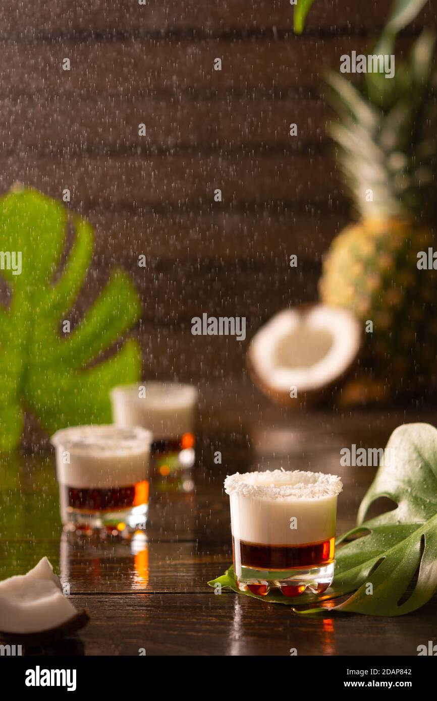 Tropical alcoholic shots decorated with coconut flakes, monstera flower ...
