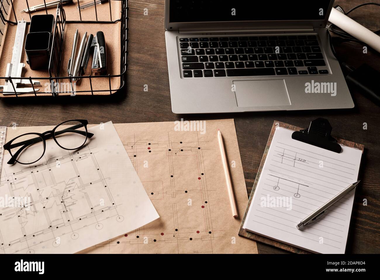 Laptop, pencil, pen on clipboard with papers and eyeglasses on ...