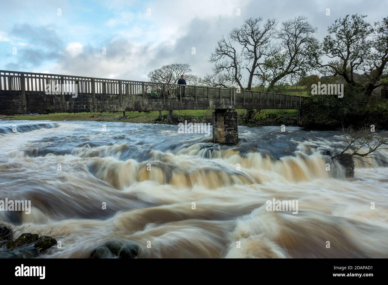 Family with children crossing the footbridge at Linton Falls waterfall ...