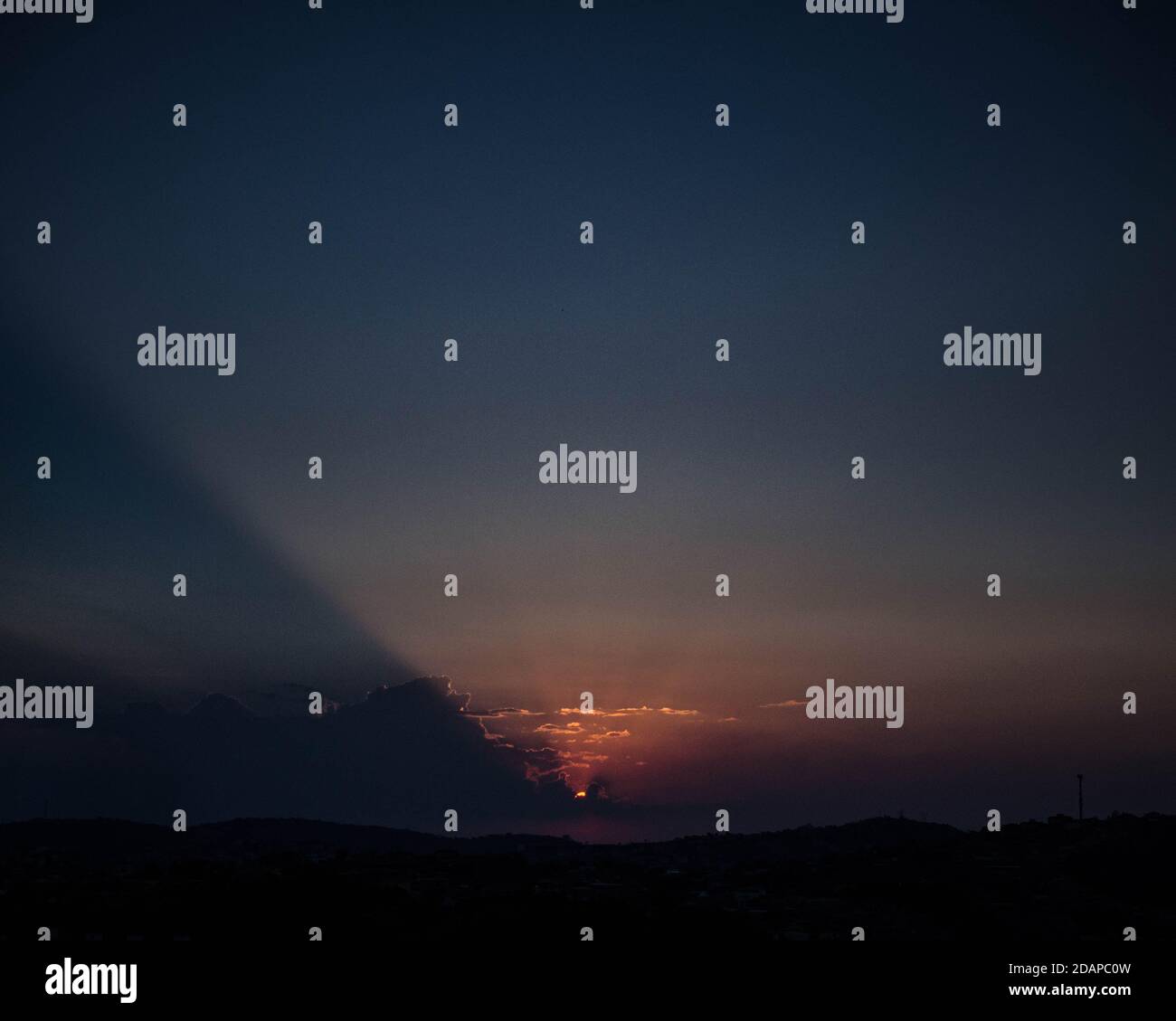 Amazing view of the setting down sun on the horizon with rays of ...