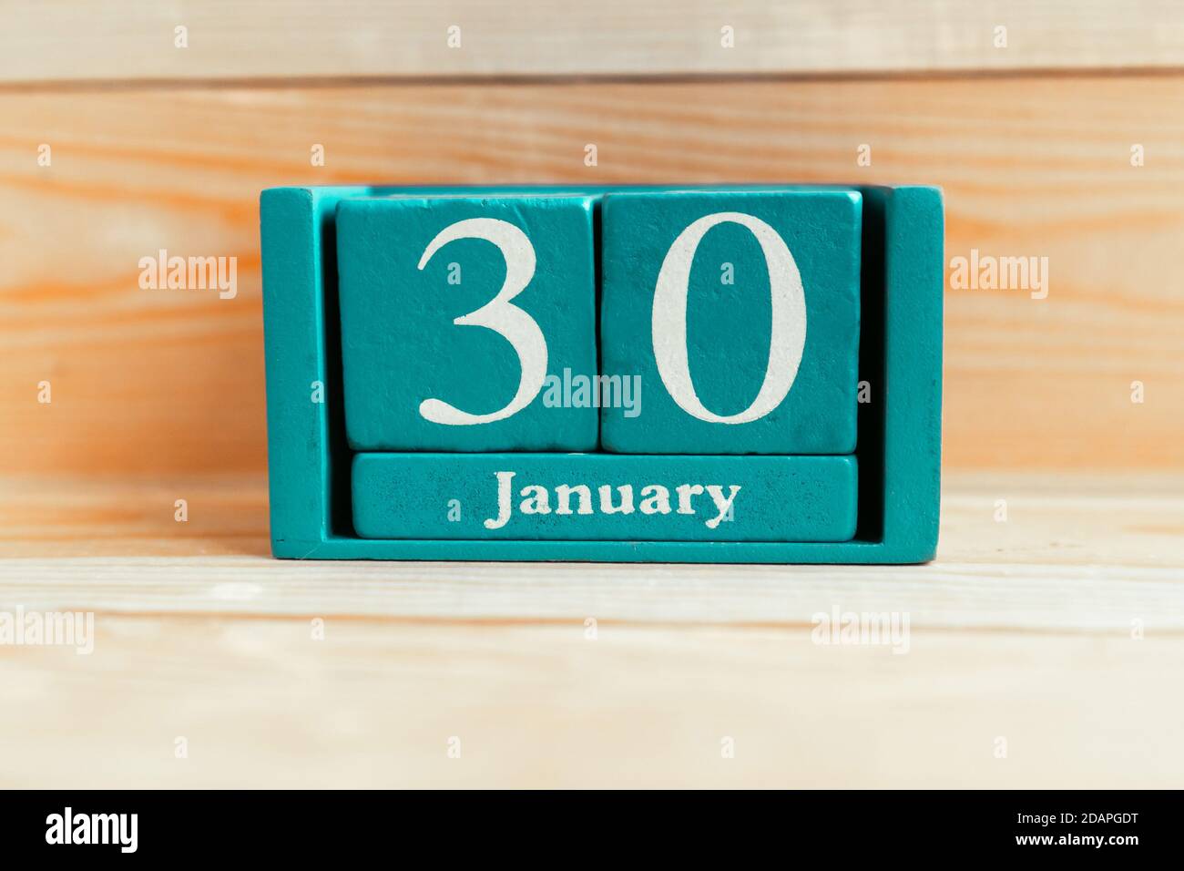 January 30. Blue cube calendar with month and date on wooden background ...