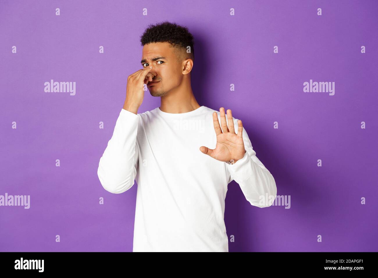 Image of african-american guy rejecting something with awful smell ...