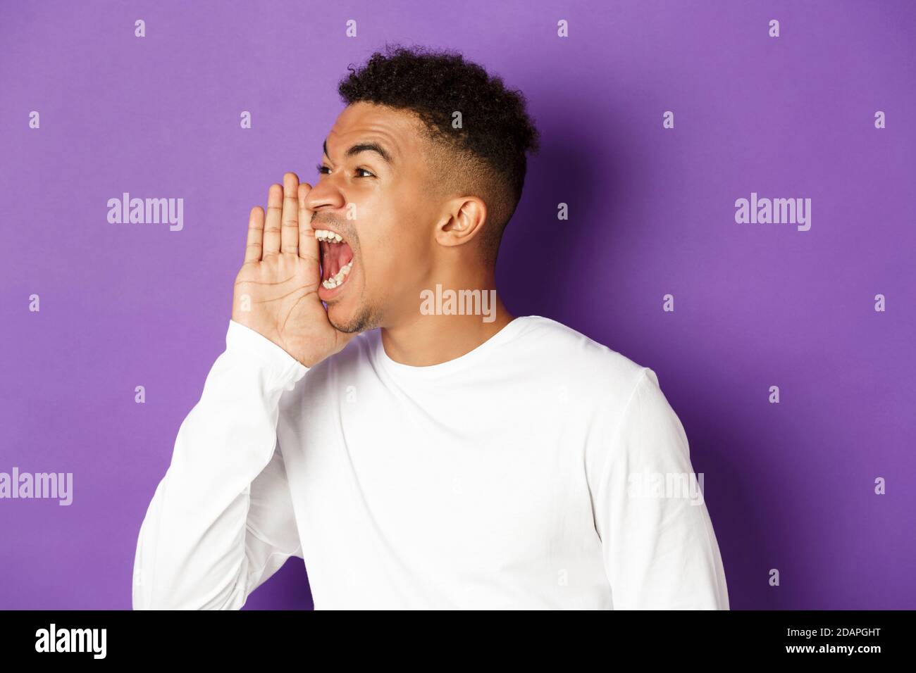 Image of african-american young man calling for someone, yelling and ...