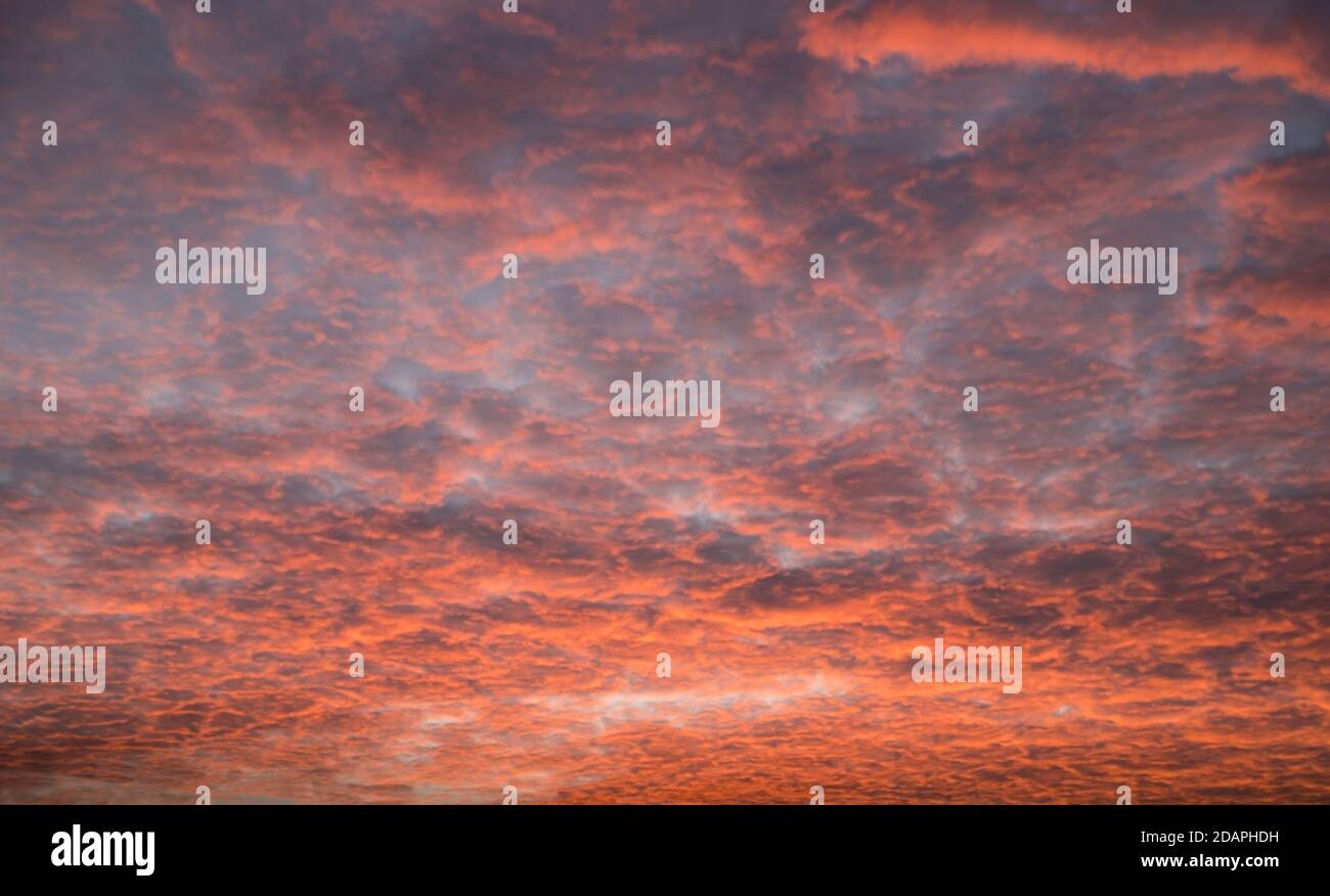 Small clouds in the sky are highlighted red at sunset. Horizontal ...