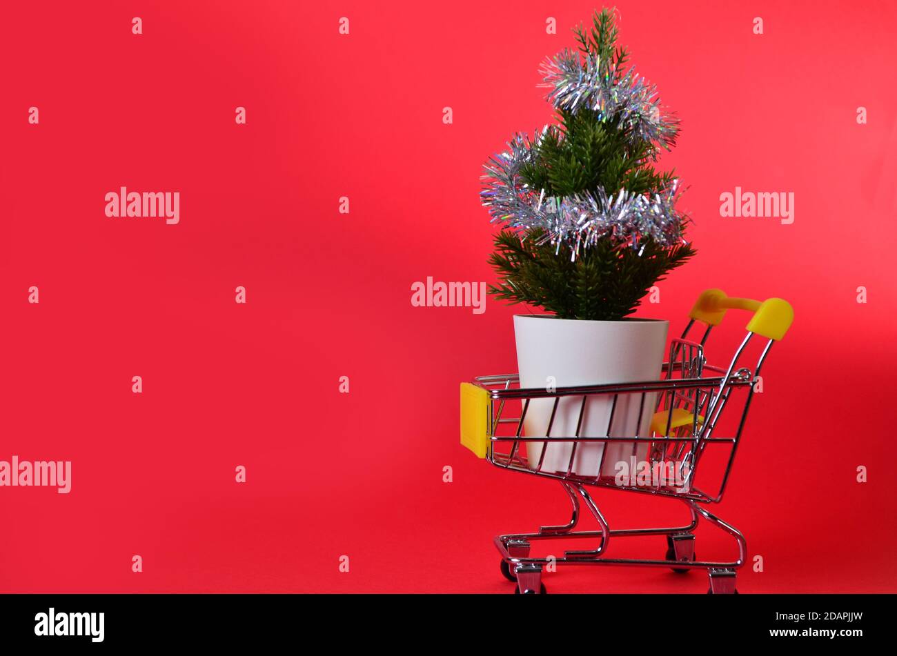 Trolley with Christmas tree decorations on red. Branches of a Christmas ...