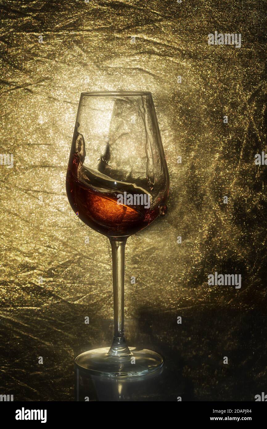 glass of Brandy on a golden background Stock Photo - Alamy