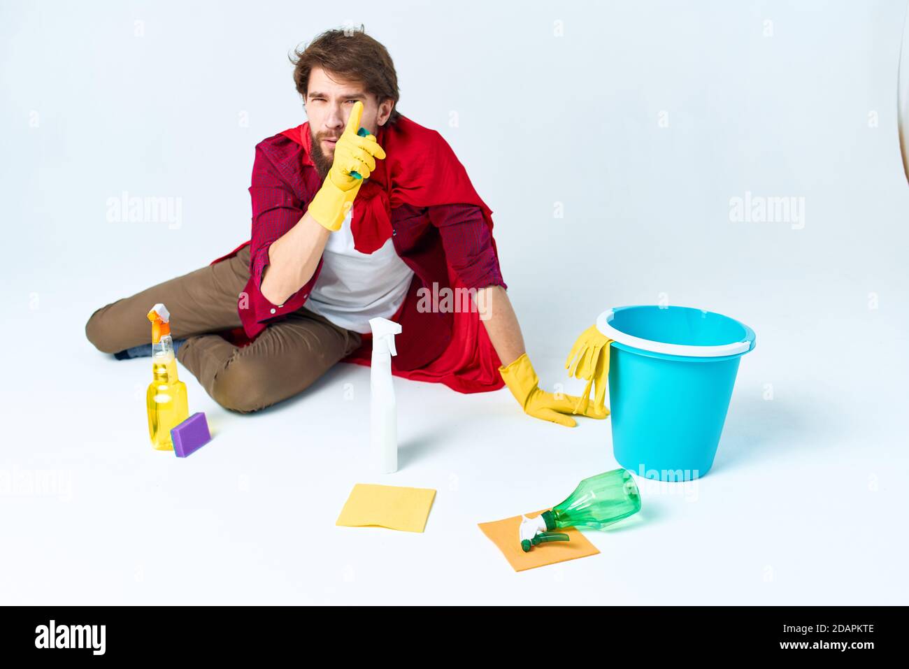 cleaner with cleaning supplies in a red raincoat on the floor of the ...