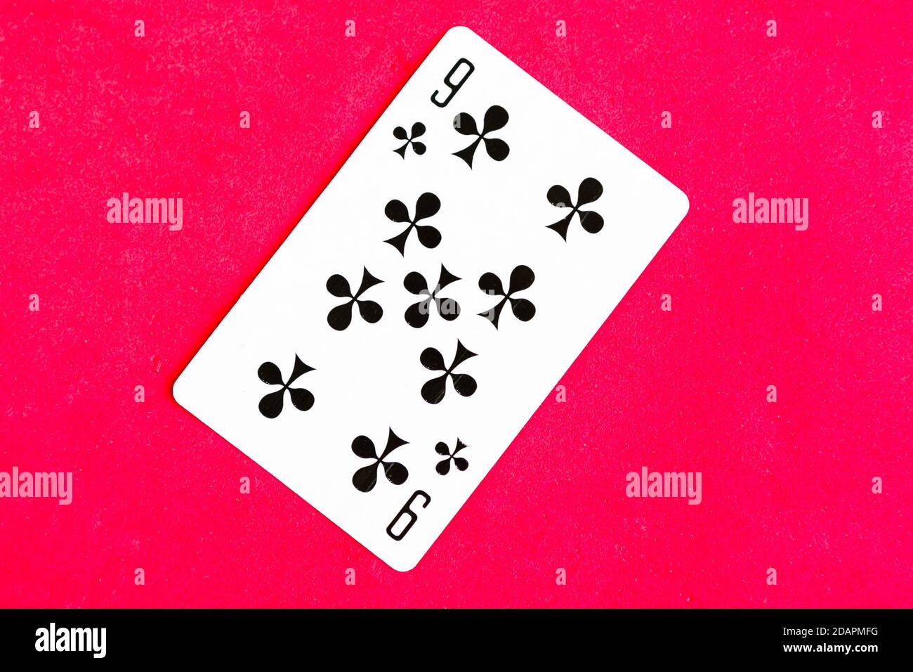 Nine of Club playing card, red background Stock Photo - Alamy