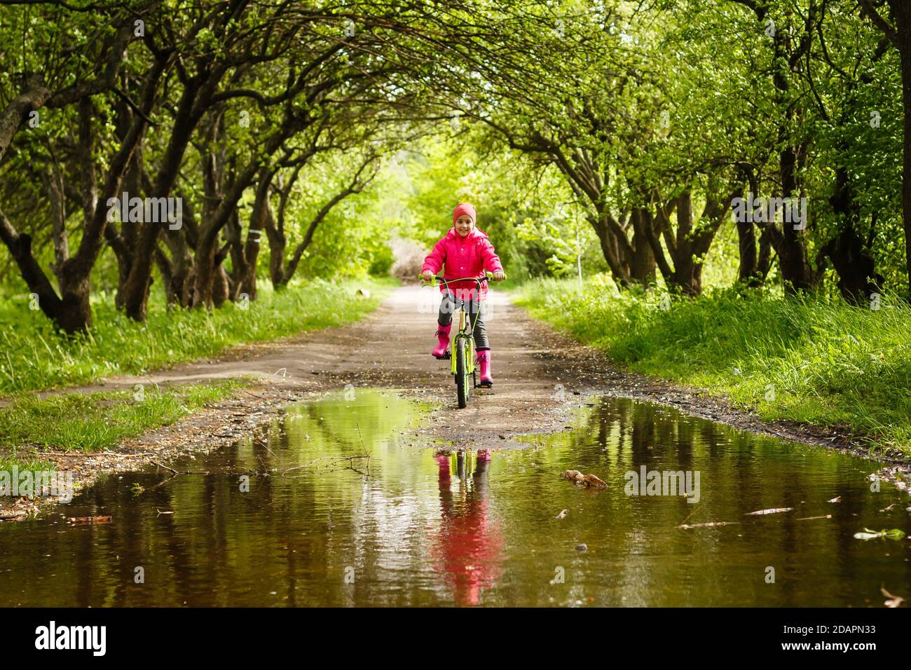 little girl riding bike in water puddle Stock Photo - Alamy
