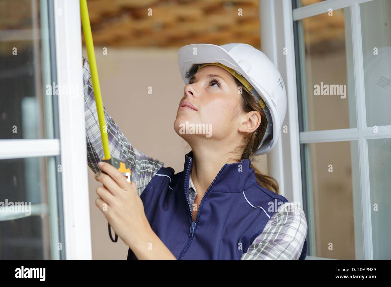 portrait of a woman measuring window frame Stock Photo - Alamy