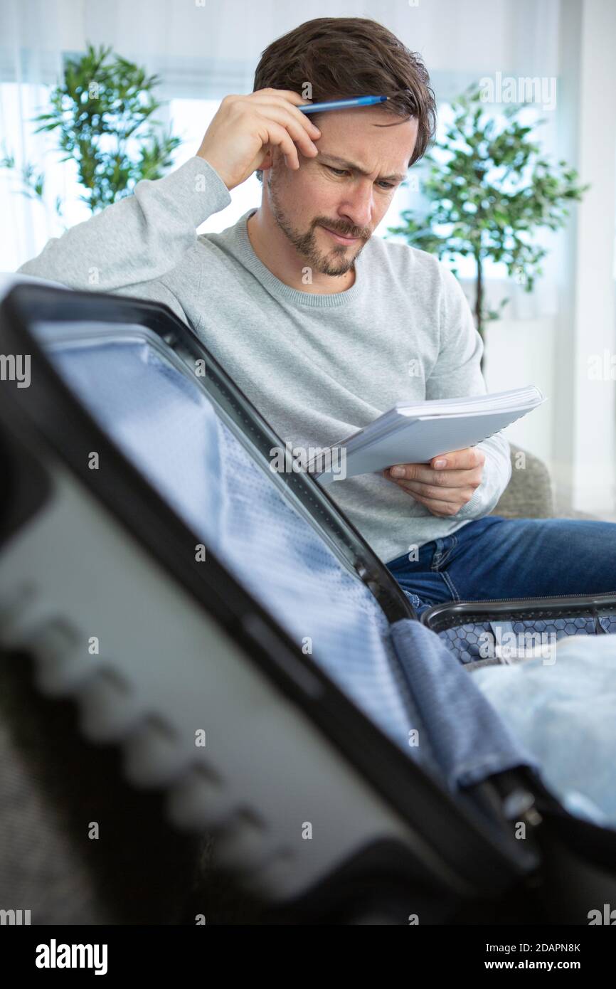 young man doing a packing list Stock Photo - Alamy
