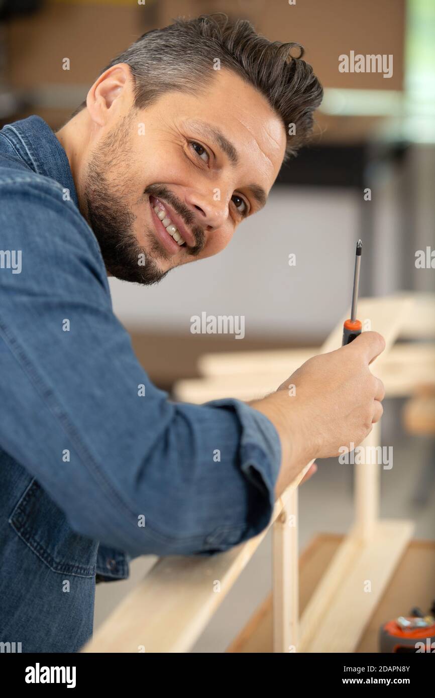successful furniture assembly worker finishes assembling shelf Stock ...