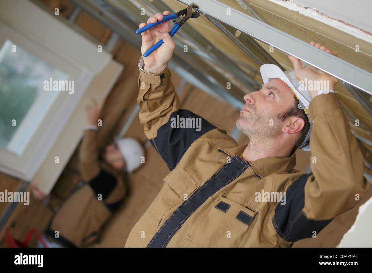 construction worker using pliers to install celiling panel Stock Photo ...