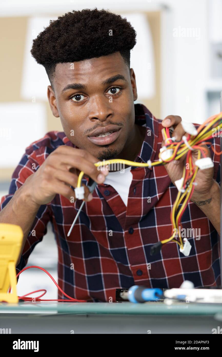 confused man is holding cables in his hand Stock Photo - Alamy