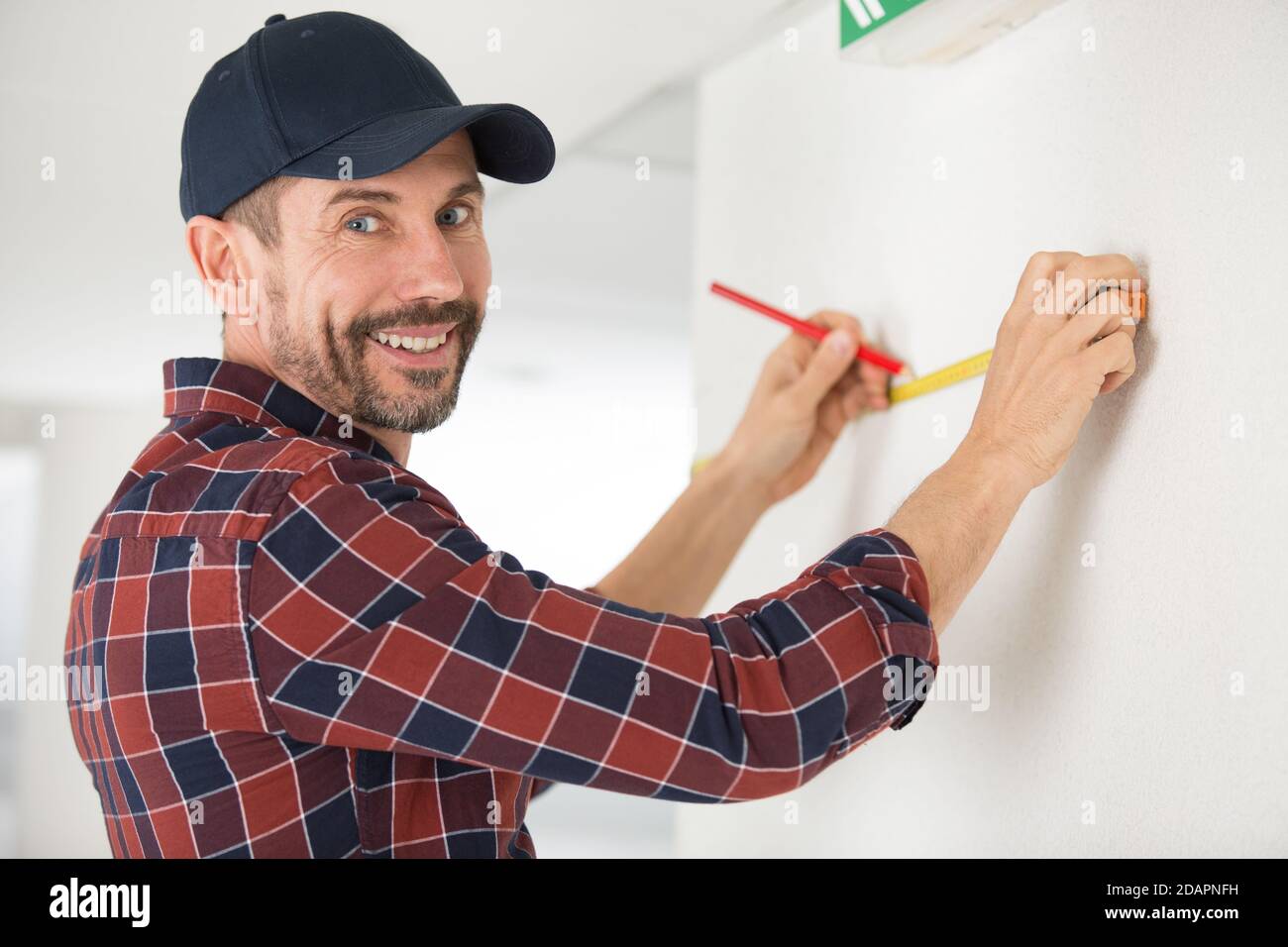 man measuring the wall with a measuring tape Stock Photo - Alamy