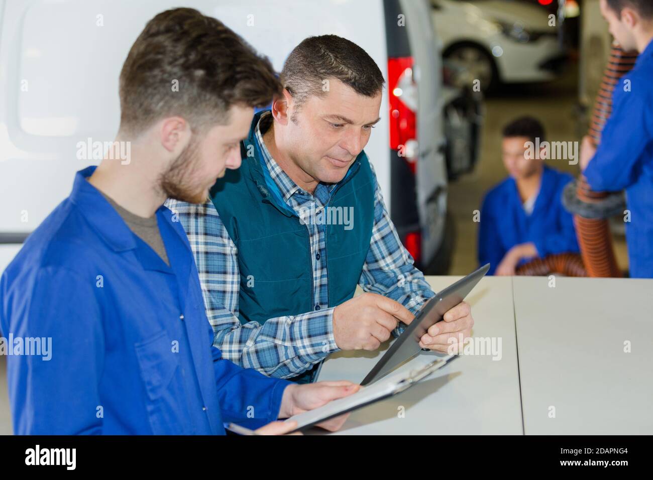 portrait of workers using a table Stock Photo - Alamy