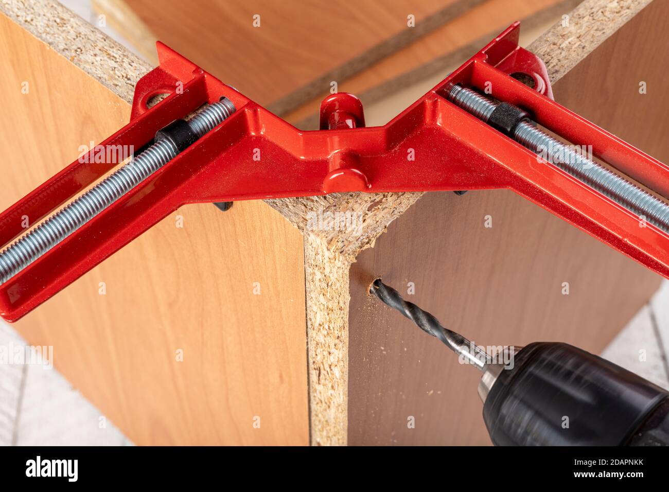Chipboard in an angular carpentry clamp. Drilling in a furniture board ...