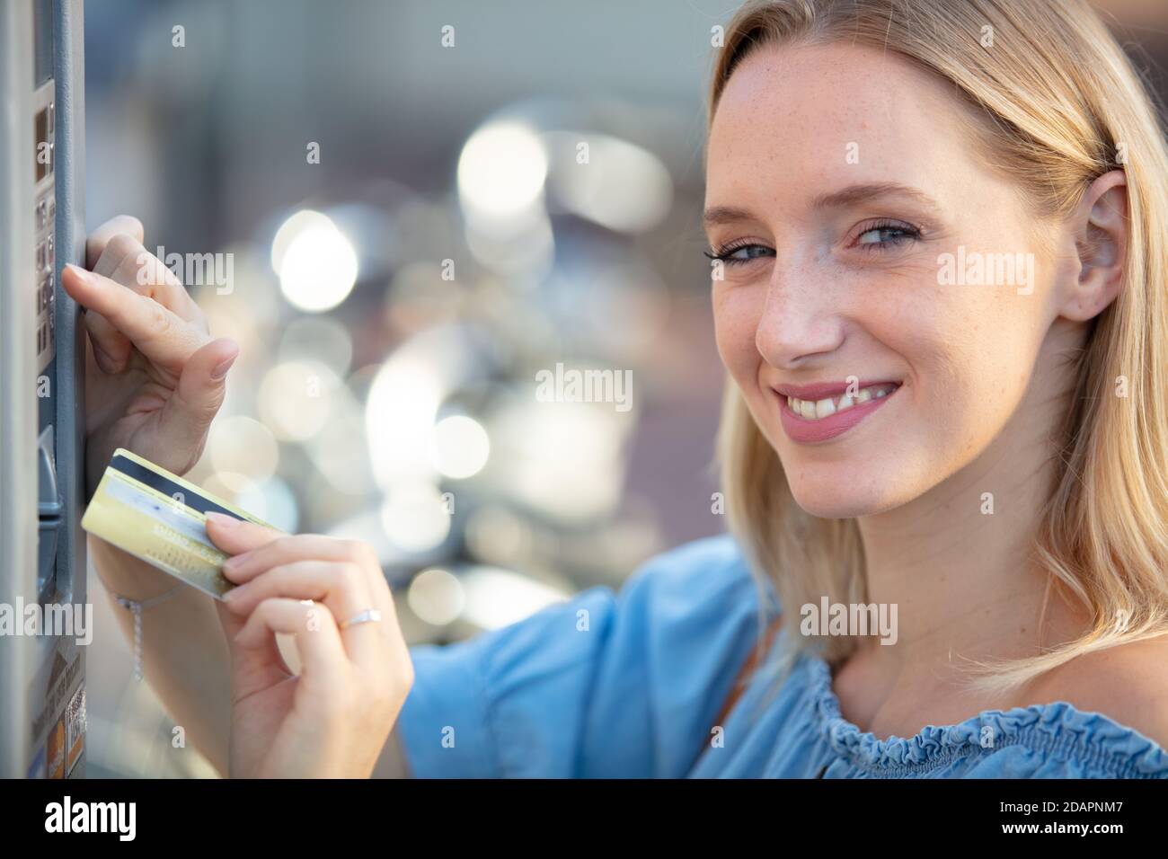woman in blue at automatic payment machine using card Stock Photo - Alamy